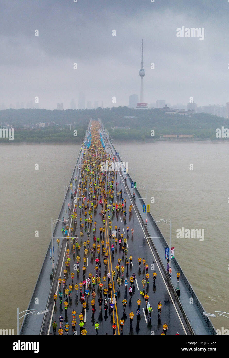 Wuhan. 9th Apr, 2017. Runners run on the Yangtze River Bridge during ...