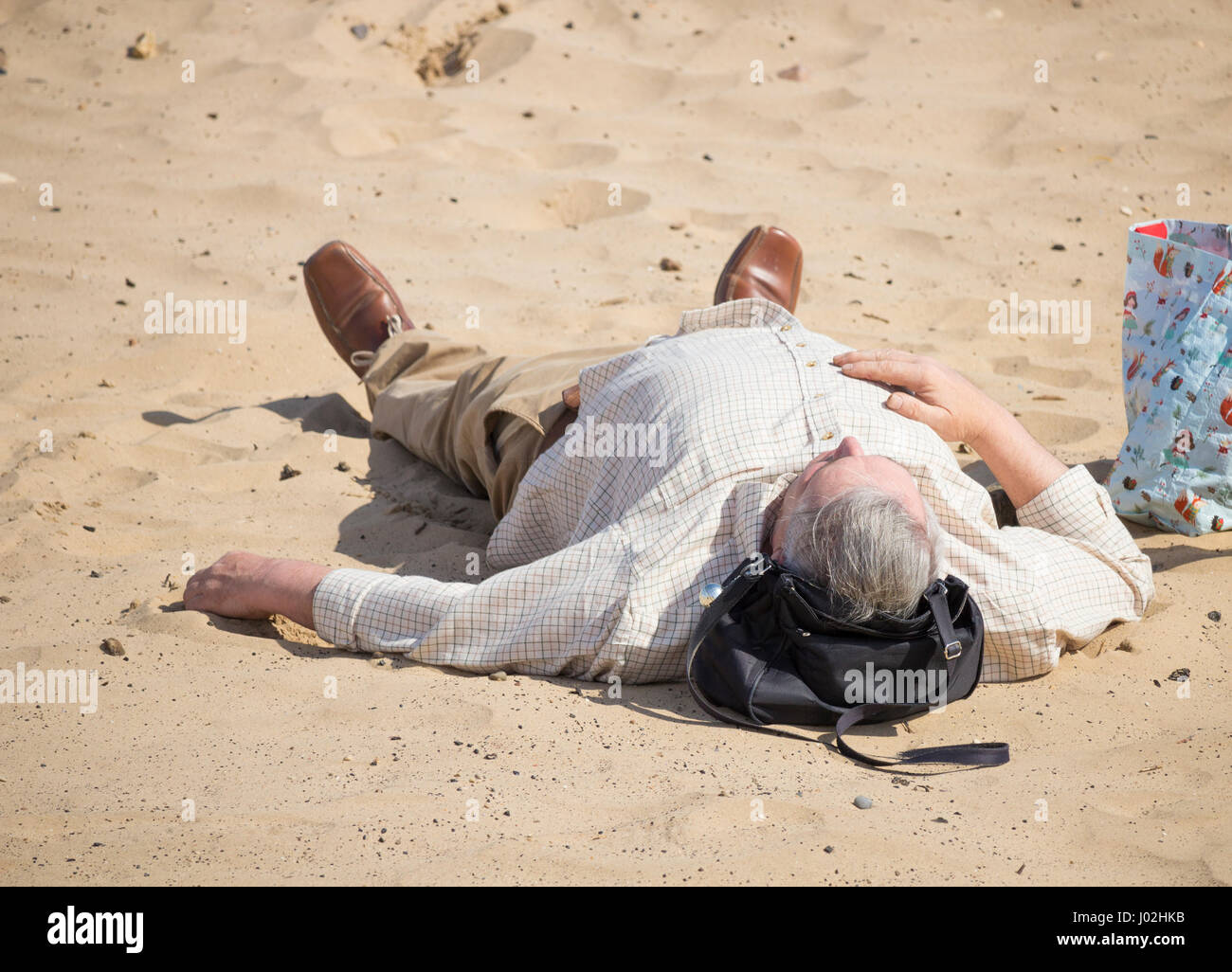 Elderly man sleeping on beach hi-res stock photography and images - Alamy