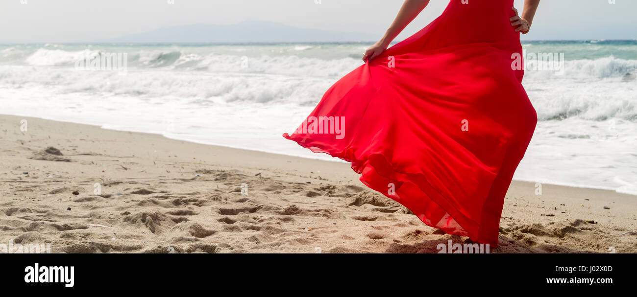 Beautiful red dress flowing in the wind at the beach. Cropped. Soft ...