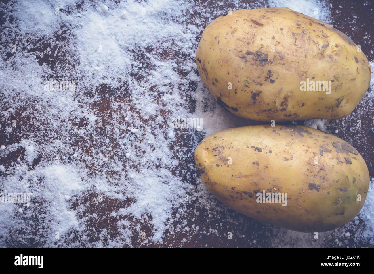 two potatoes on wooden table Stock Photo - Alamy