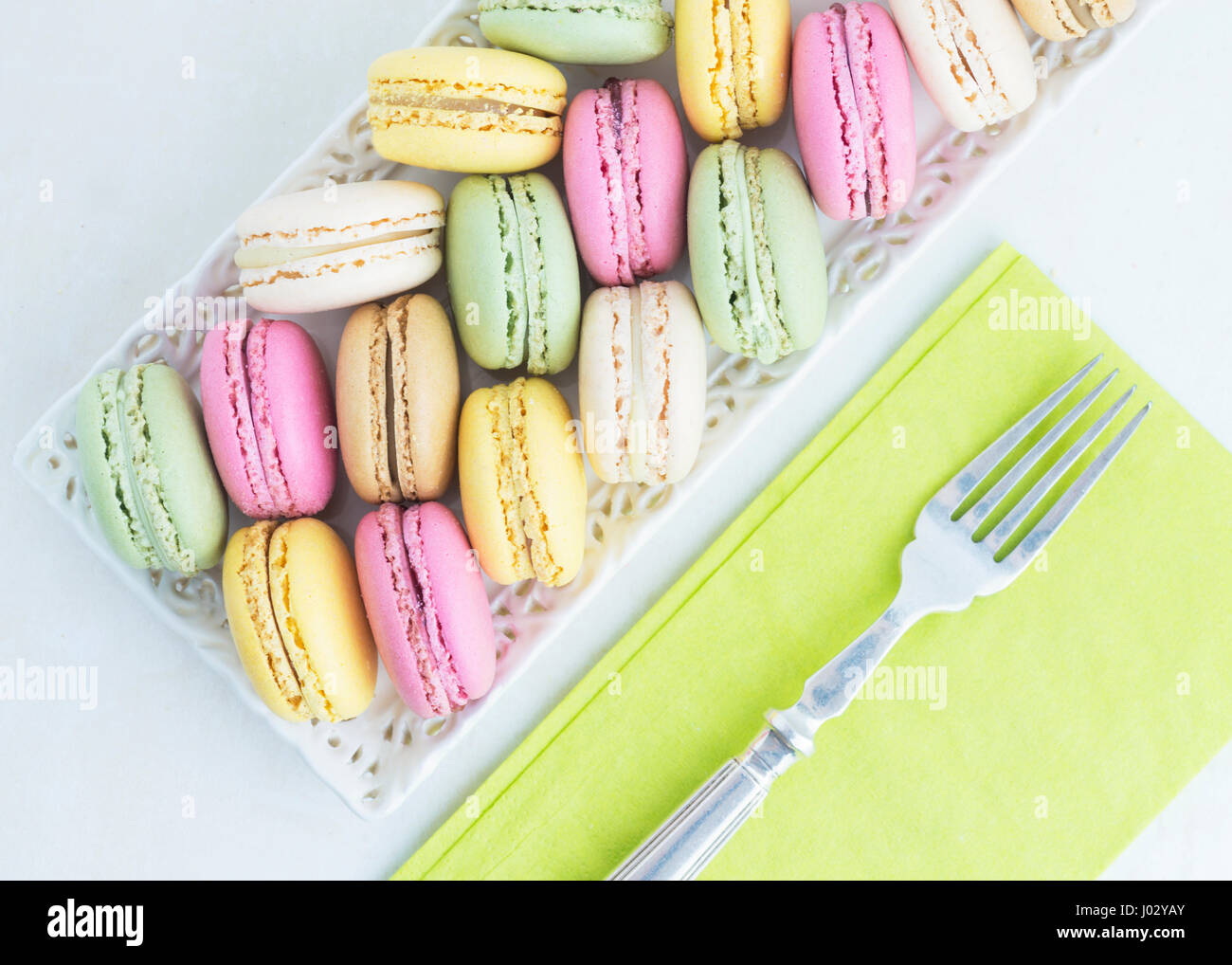 horizontal image of macaroons in pretty summer colors with a lime green ...