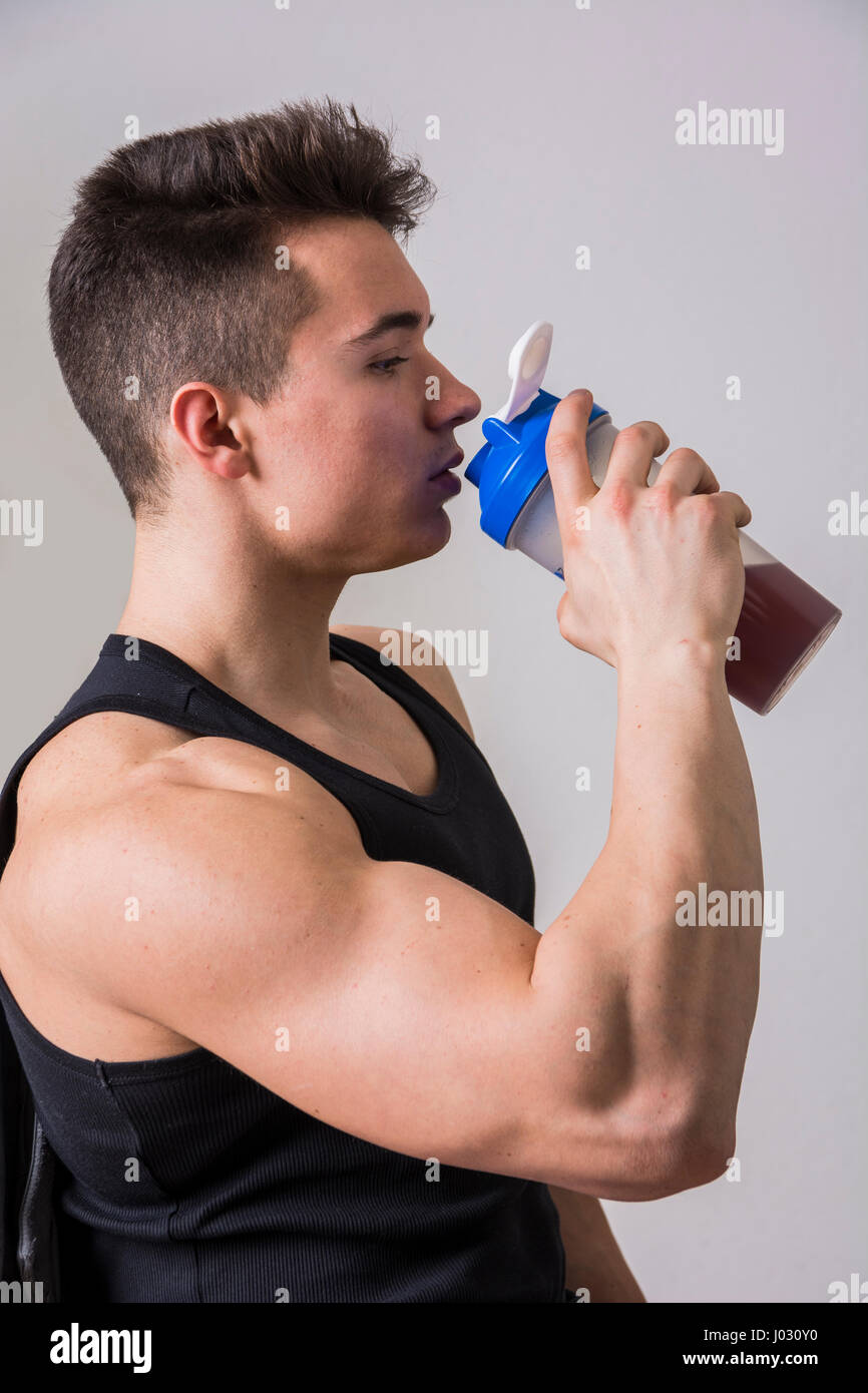 Muscular young male bodybuilder holding shaker Stock Photo - Alamy