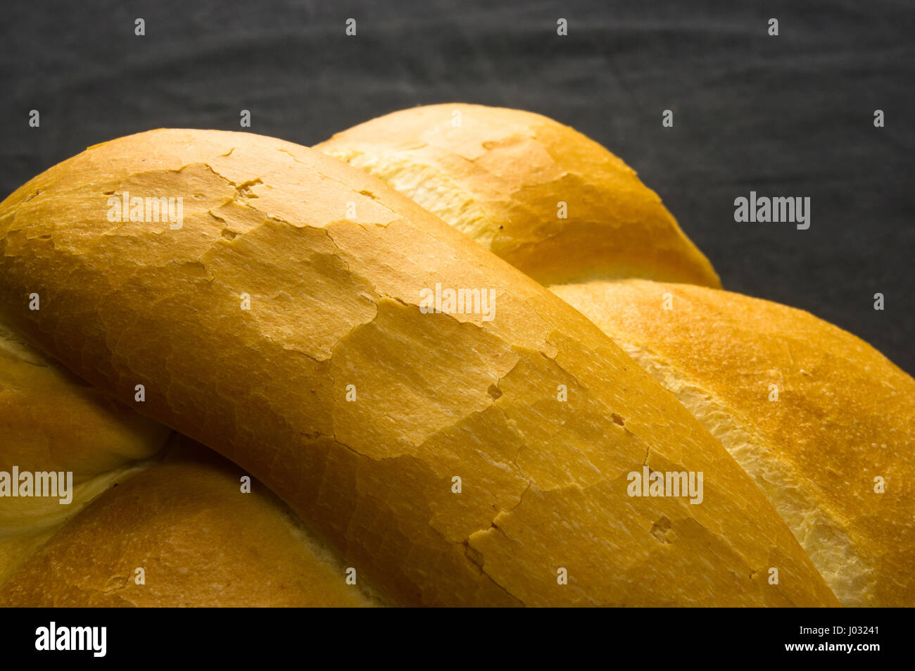 fresh braided loaf of white wheat bread on black background Stock Photo ...