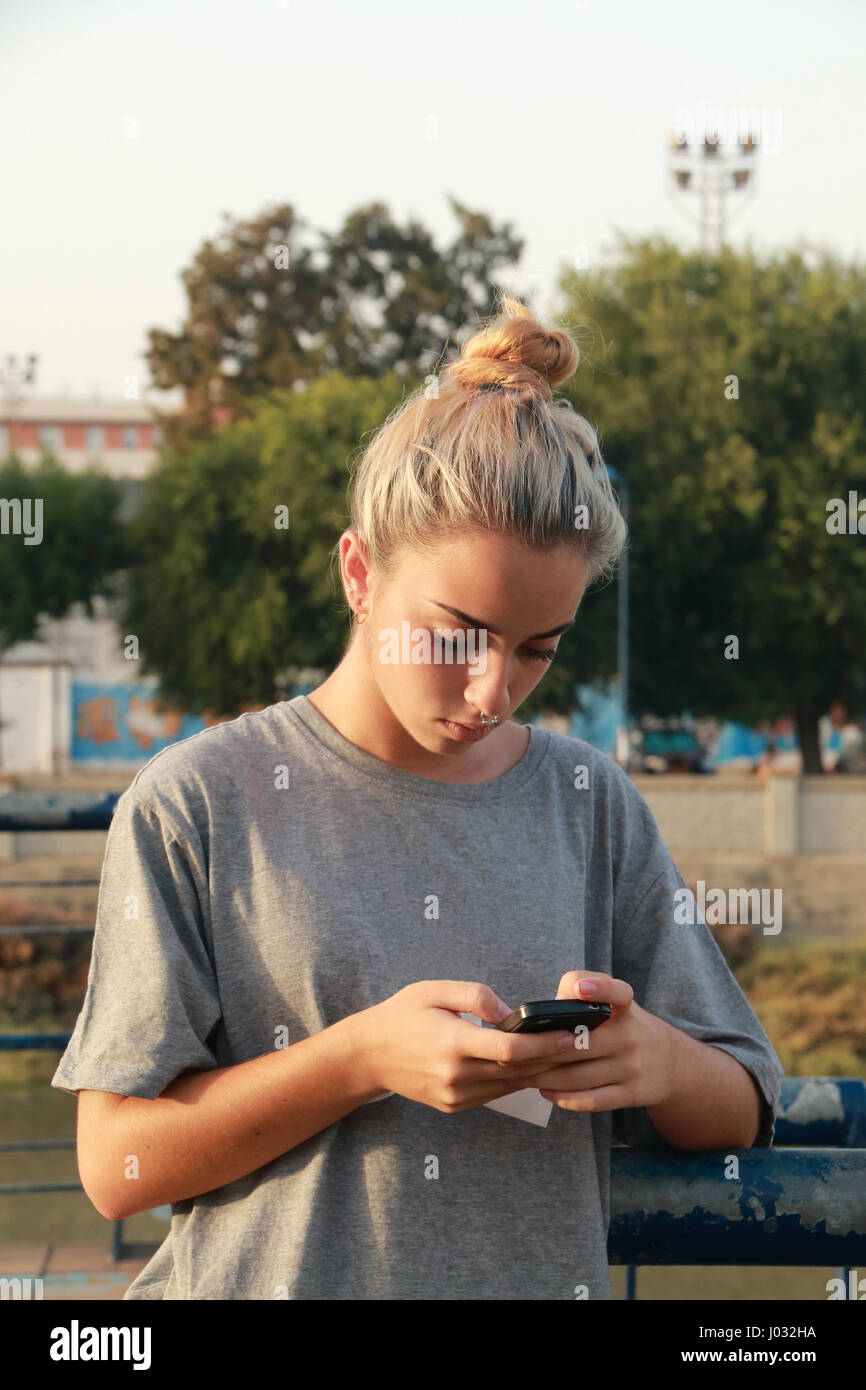 Girl typing on her mobile phone Stock Photo - Alamy