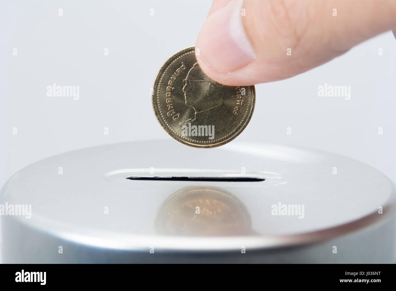 Closeup for drop thai coin to donation or savings canned Stock Photo ...