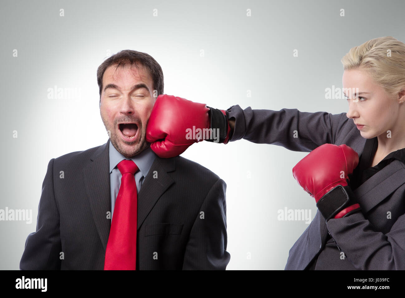 A businessman receiving punch to the side of his head from his co ...