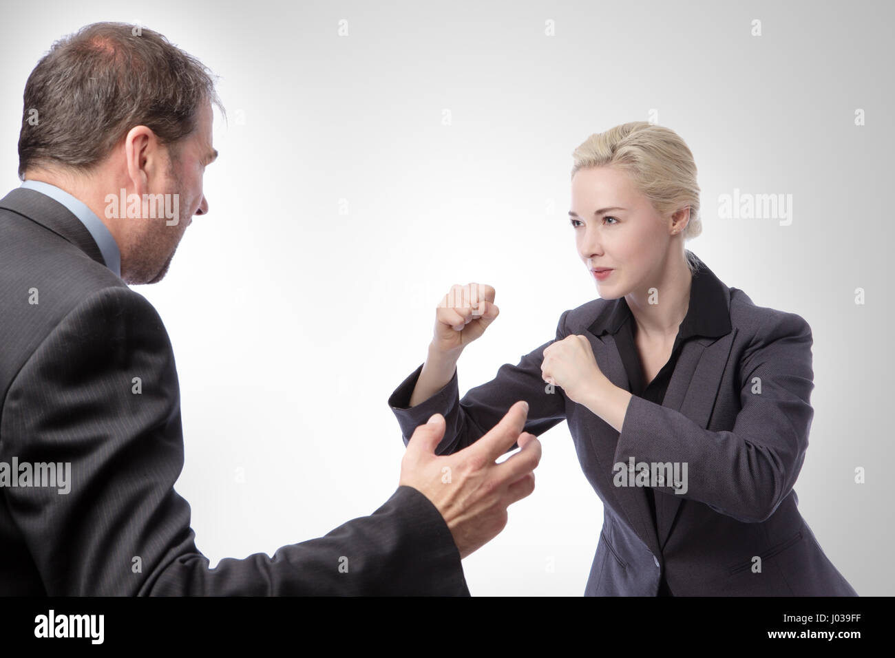 Studio shot of two co-workers wearing suits, fighting in the office ...