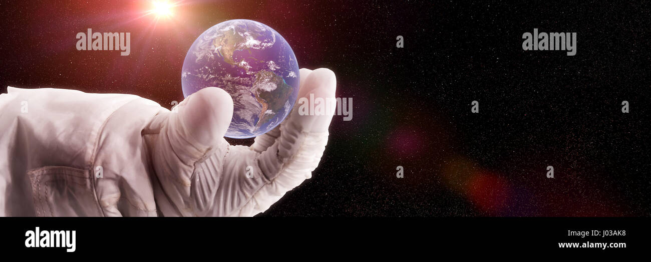 astronaut’s hand holding planet Earth in front of deep space with a ...