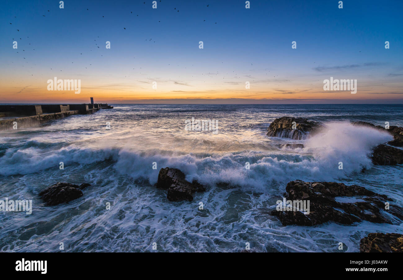 Sunset over Atlantic Ocean. View with small lighthouse (Farolins Barra ...