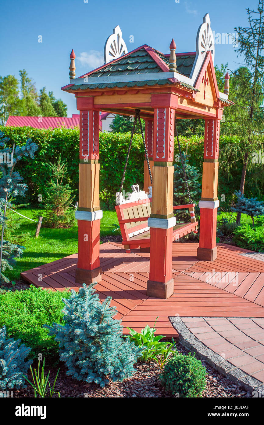 Wooden big swing in garden Stock Photo - Alamy