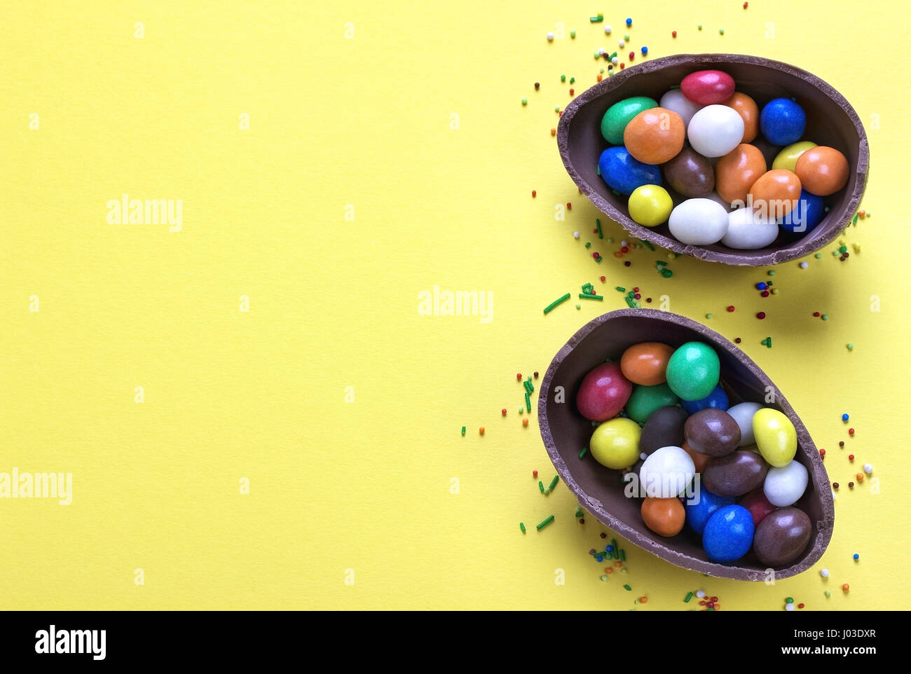 Easter chocolate egg with colorful explosion of candies and sweets on ...
