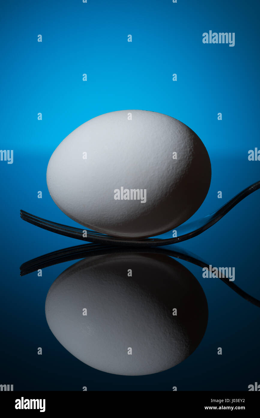 white egg lying on fork Stock Photo - Alamy