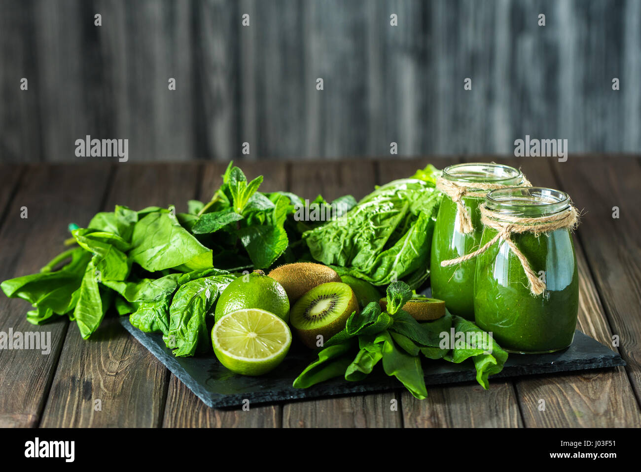 Blended green smoothie with ingredients on the stone board, wooden ...
