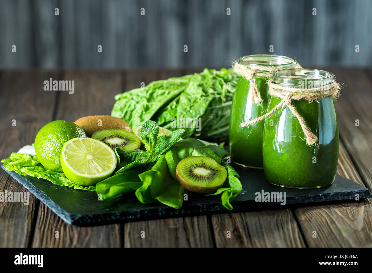 Blended green smoothie with ingredients on the stone board, wooden ...
