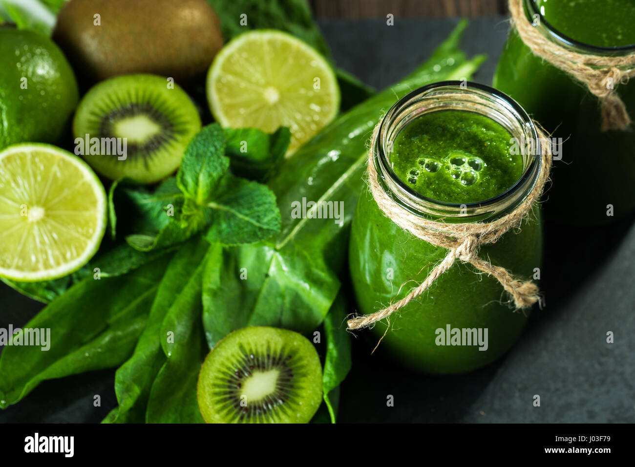 Blended green smoothie with ingredients on the stone board, wooden ...