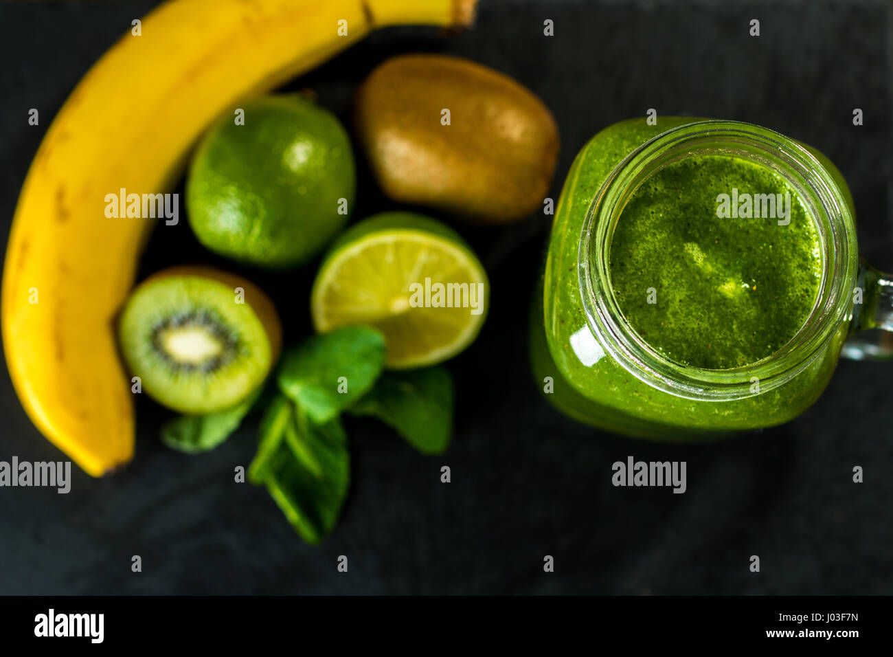 Blended green smoothie with ingredients on the stone wooden table ...