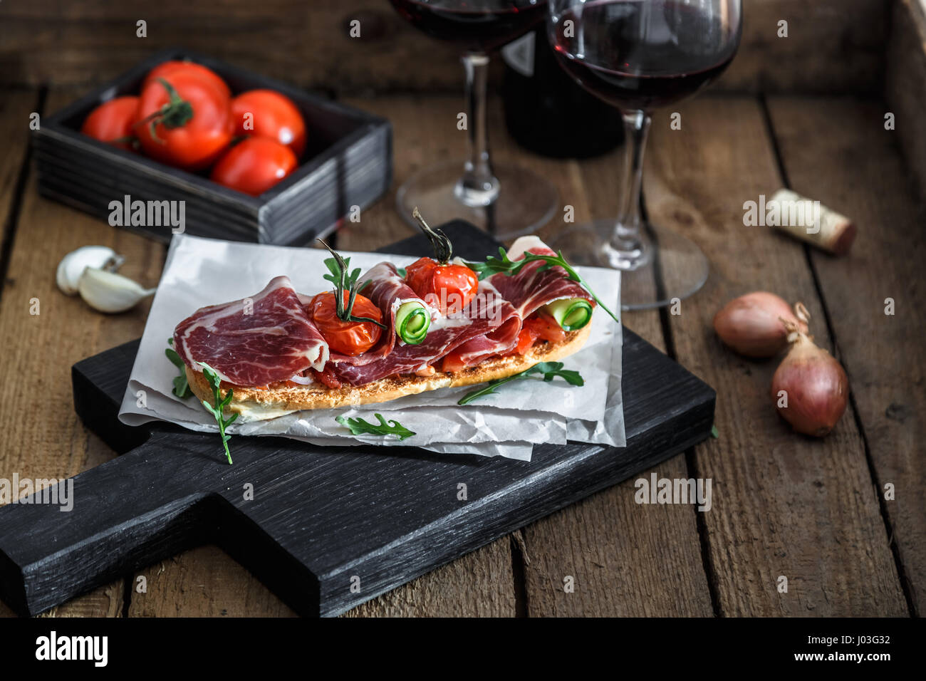 Traditional parma cured ham antipasto on wooden background, rustic ...