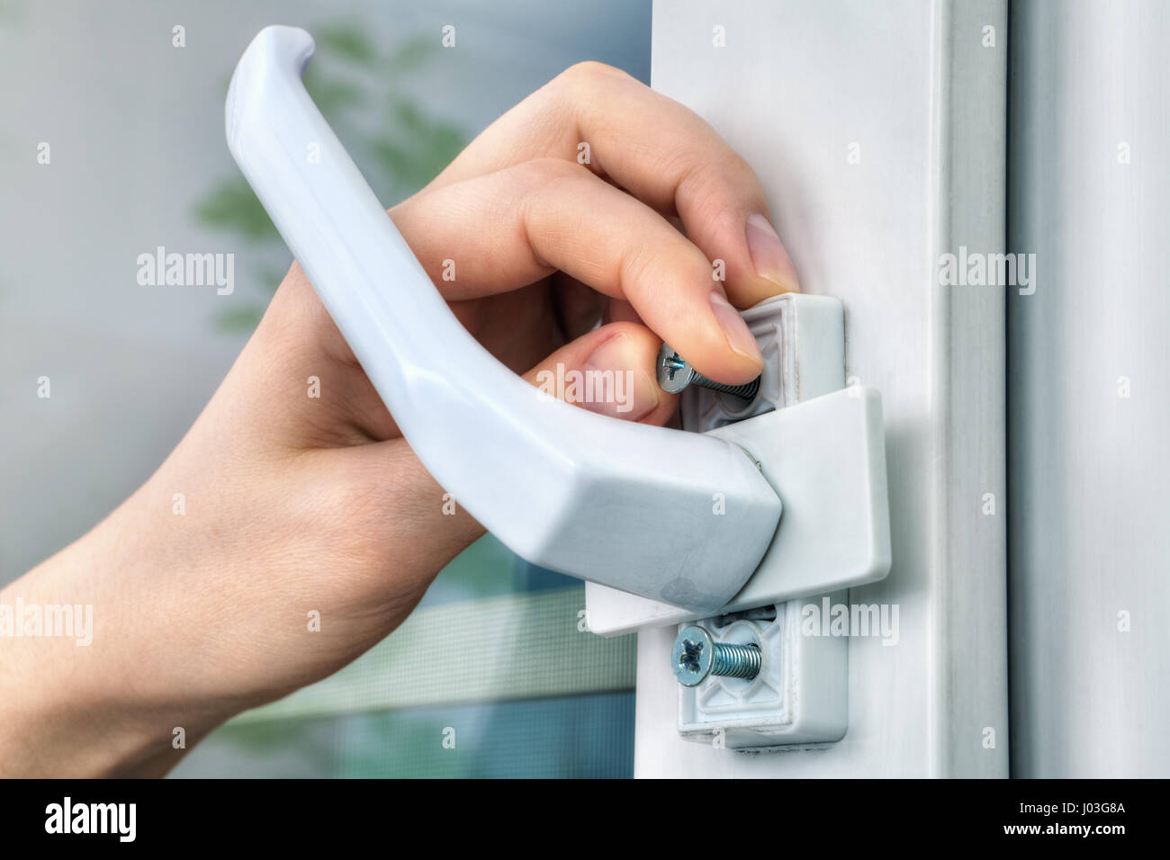 Close-up of a hand fitter, unscrewing the fixing screws of the window ...