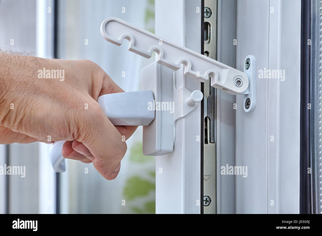 Close-up, the hand opens the PVC window by pulling the handle provided ...
