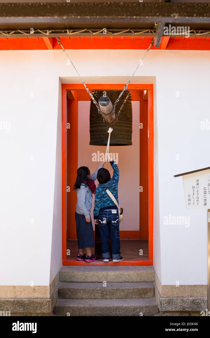 Children striking a bell Stock Photo - Alamy