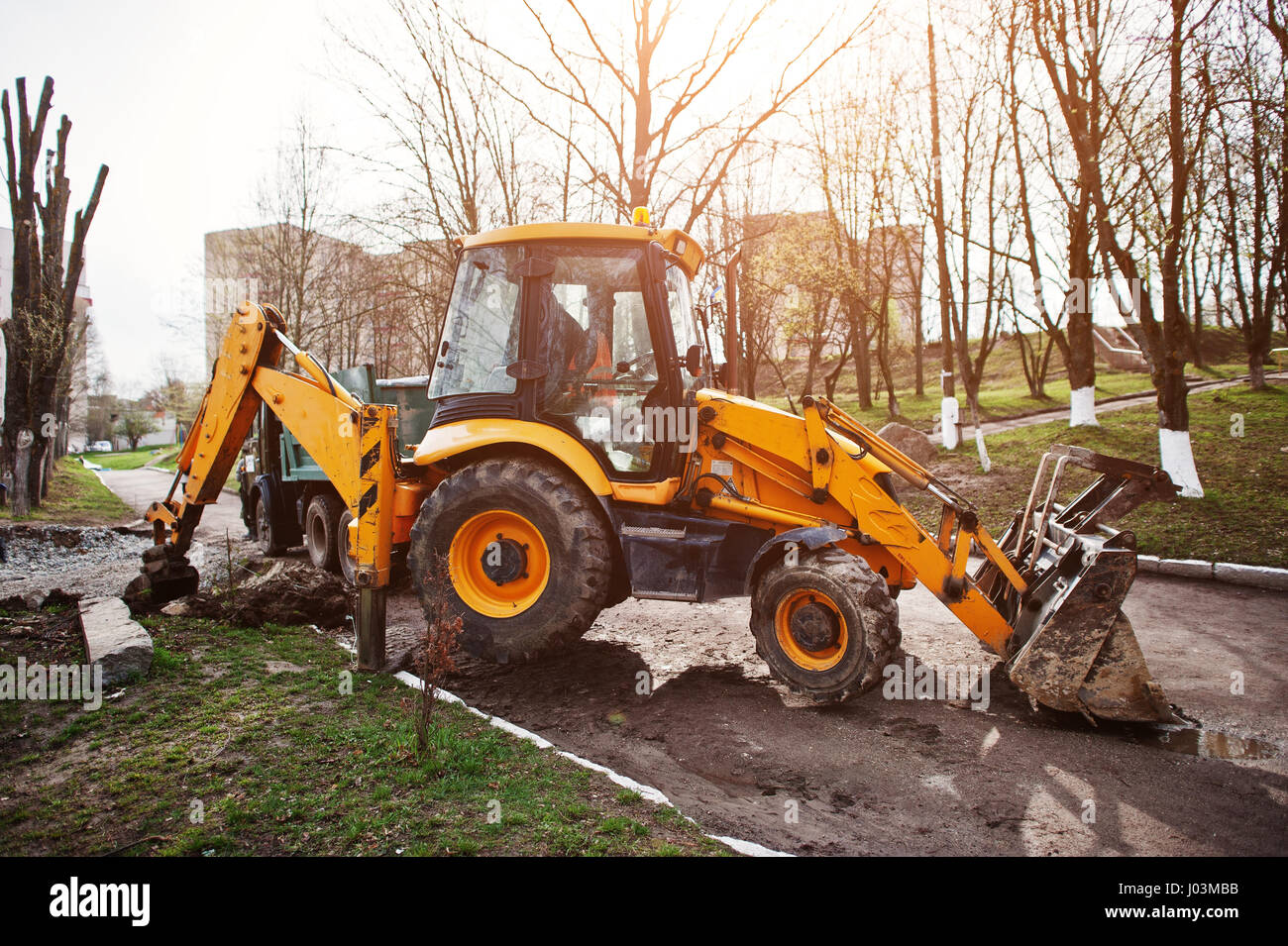 Yellow worker tractor with bucket at work Stock Photo - Alamy