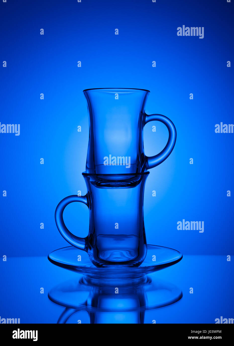 Beautiful glass tea cup on a blue background Stock Photo - Alamy