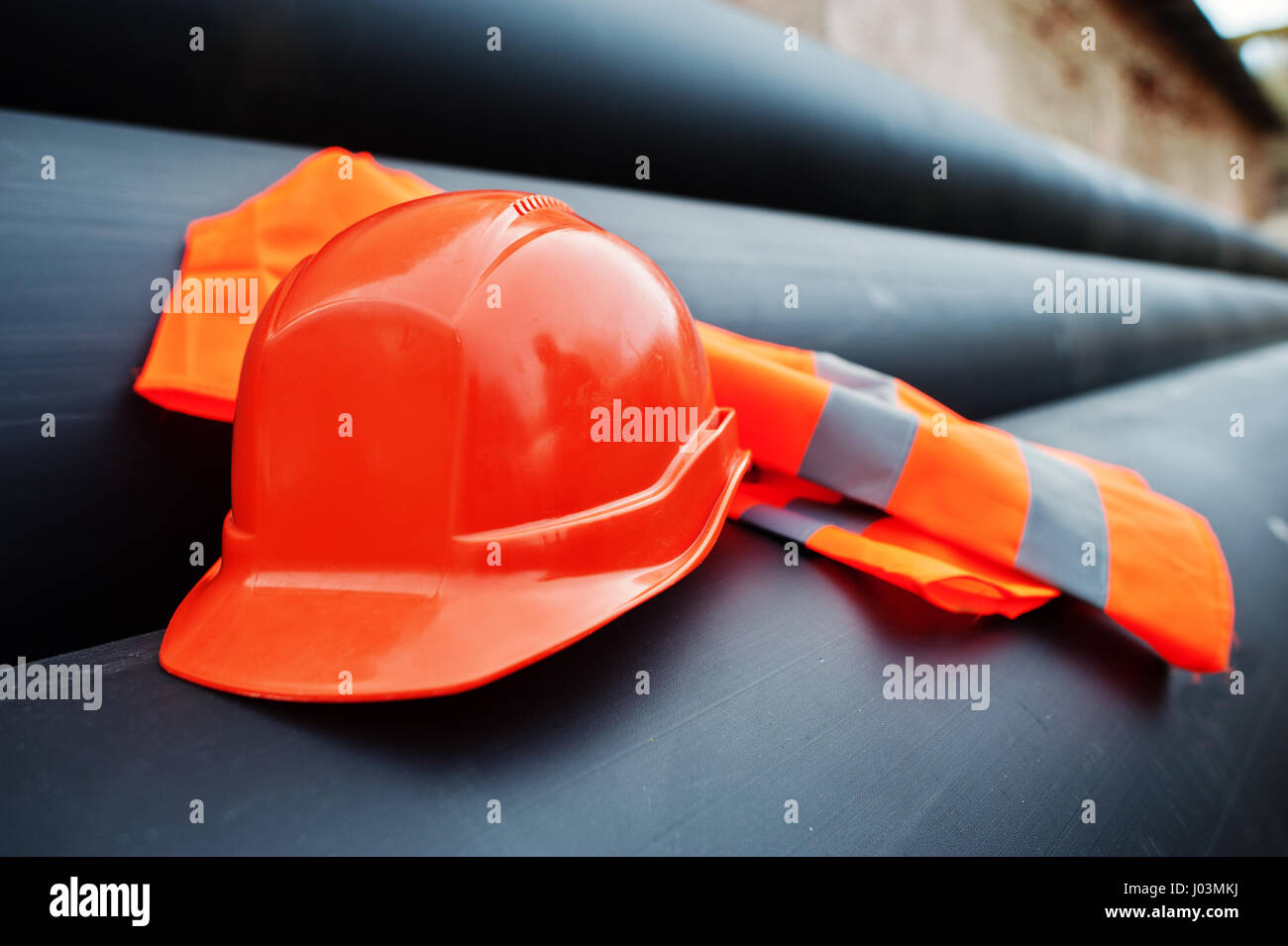 Safety orange worker helmet at steel pipes Stock Photo - Alamy