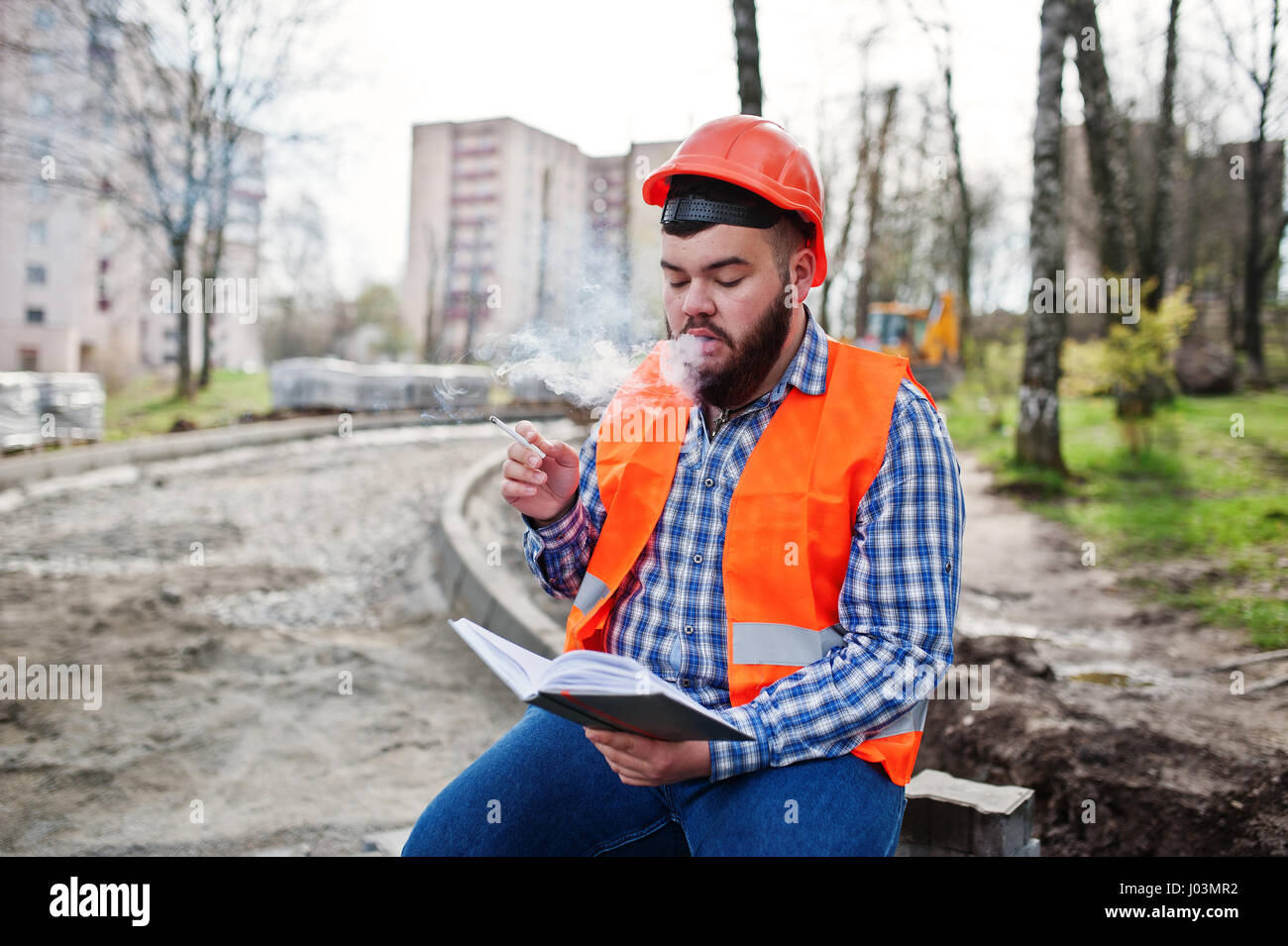 Brutal beard smoking worker man suit construction worker in safety ...