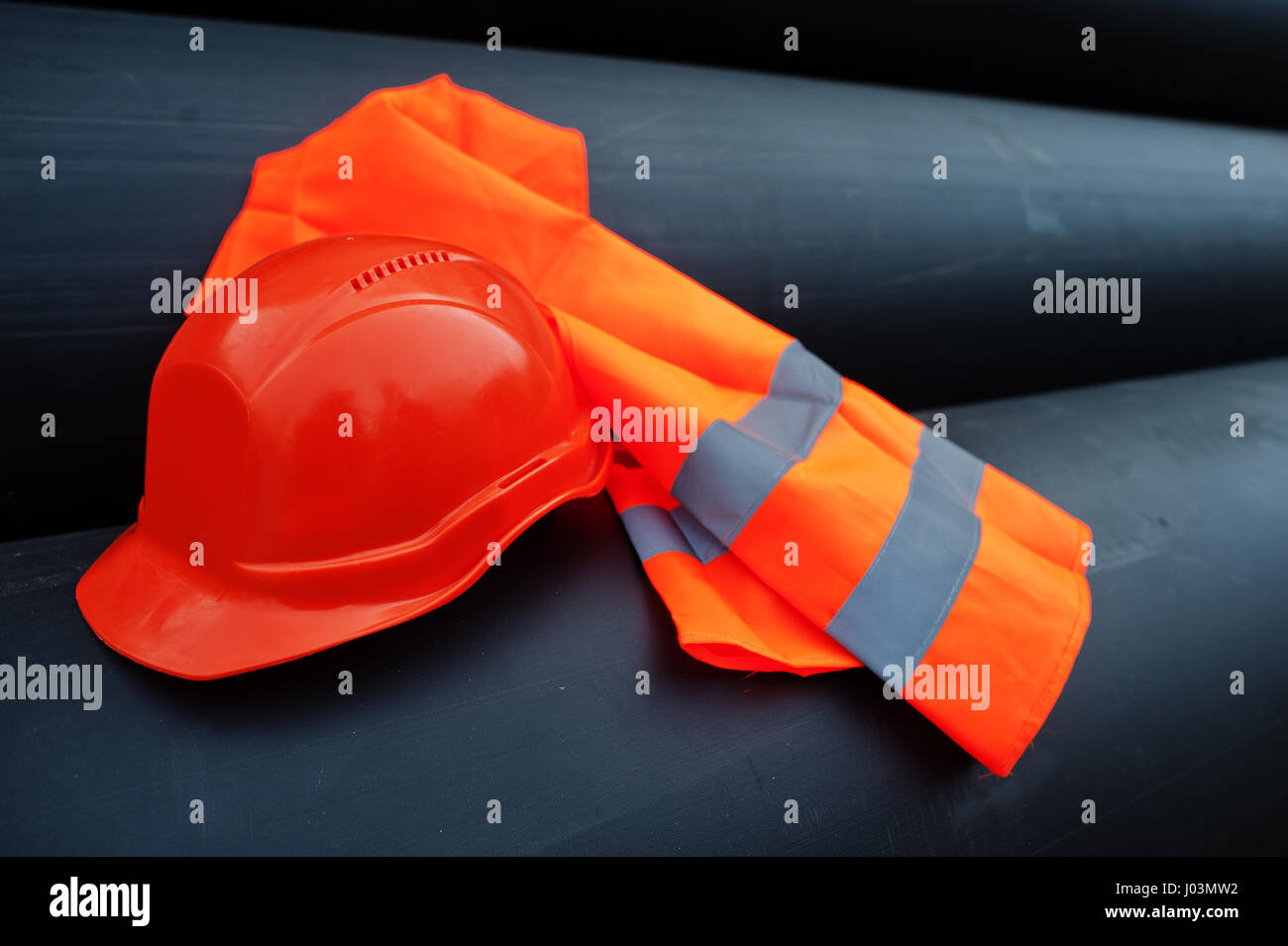 Safety orange worker helmet at steel pipes Stock Photo - Alamy
