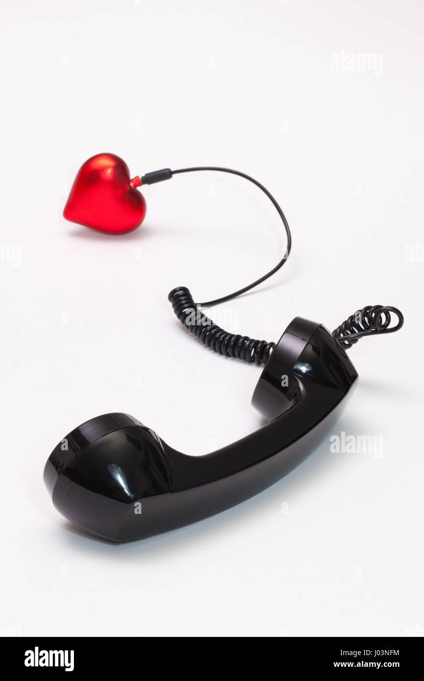 Old phone reciever and cord connection with red heart. Love hotline ...