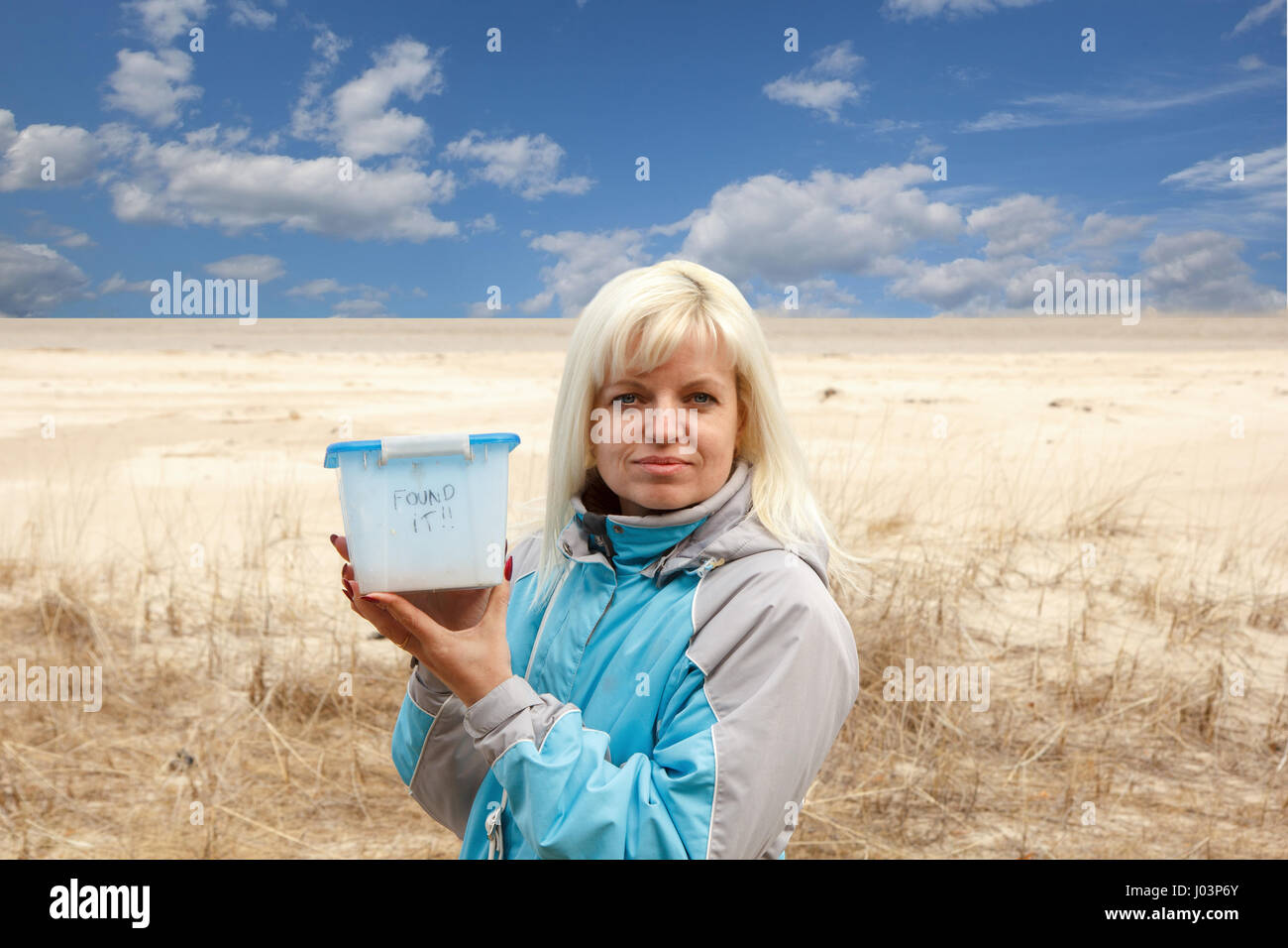 A woman and a geocaching container at the beach Stock Photo - Alamy