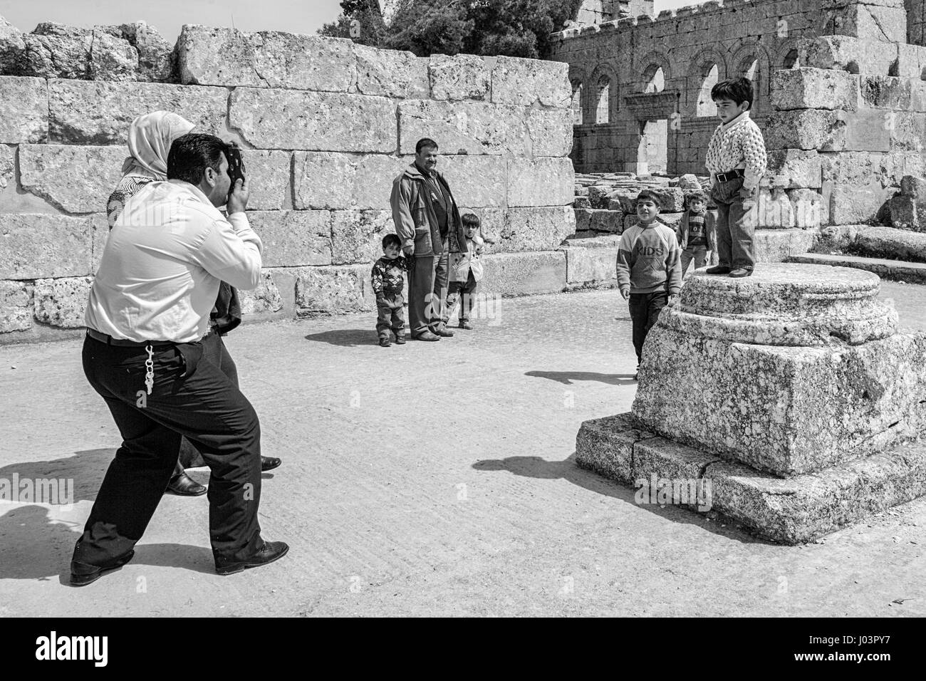 Father photographing his son in the ruins of Qala'at Samaan, Syria ...