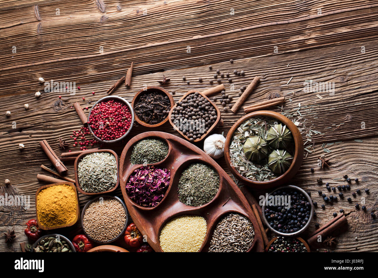 Set of colorful spices in different bowls on wooden table. Top view ...