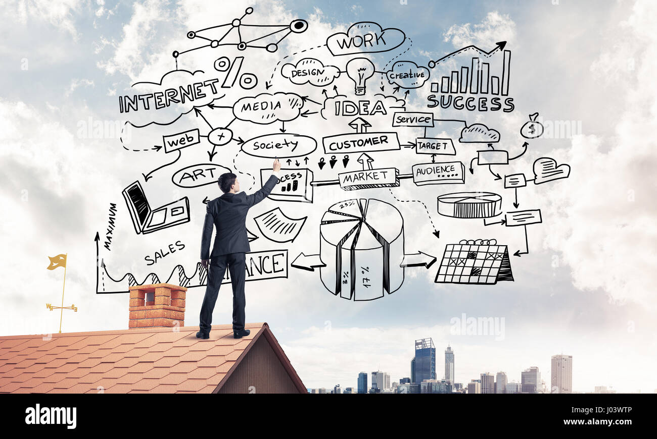 Rear view of businessman on house roof drawing his new business Stock ...