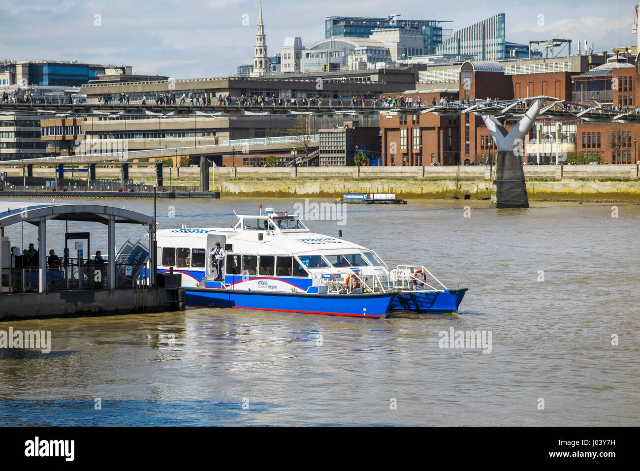 Blue and white Catamaran Thames Clipper boat forming part of the river ...