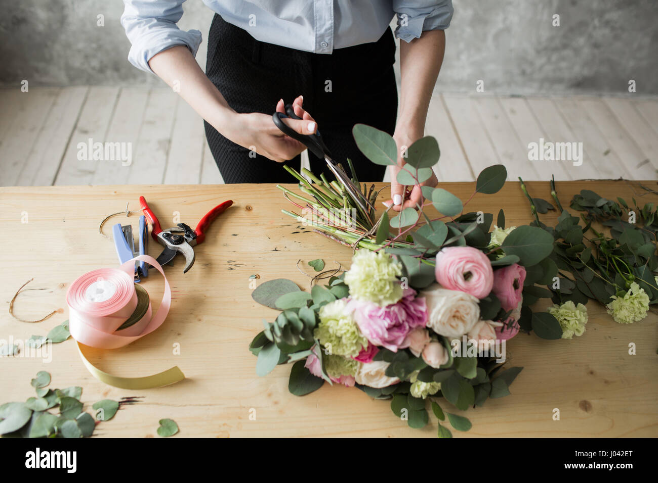 Florist at work: pretty young woman making fashion modern bouquet of ...