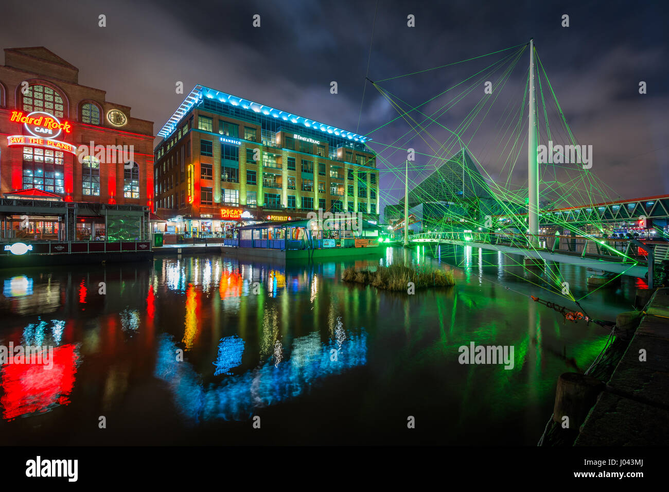 Pedestrian bridge and buildings at the Inner Harbor at night, in ...