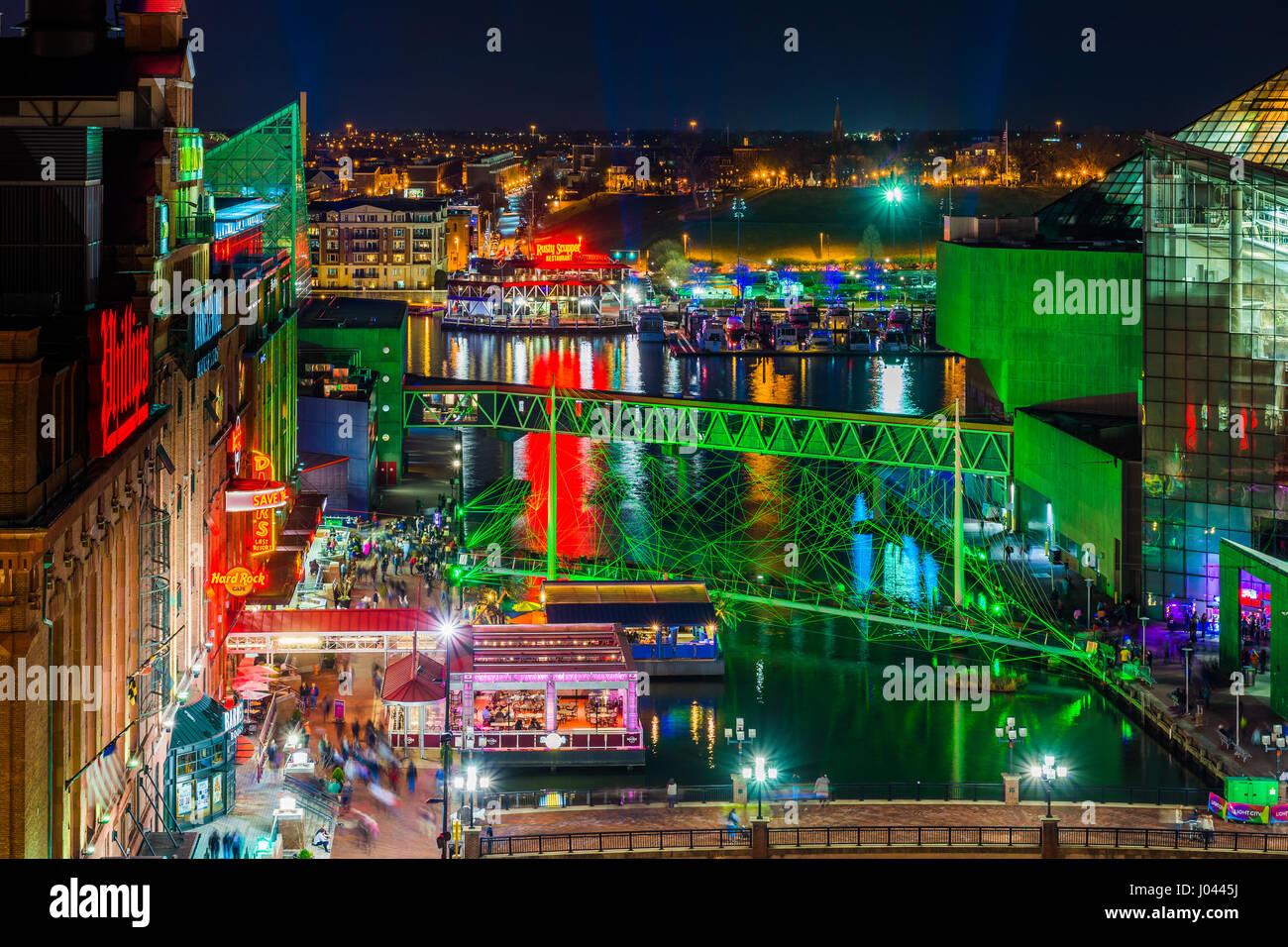 View of buildings and pedestrian bridges at the Inner Harbor at night ...