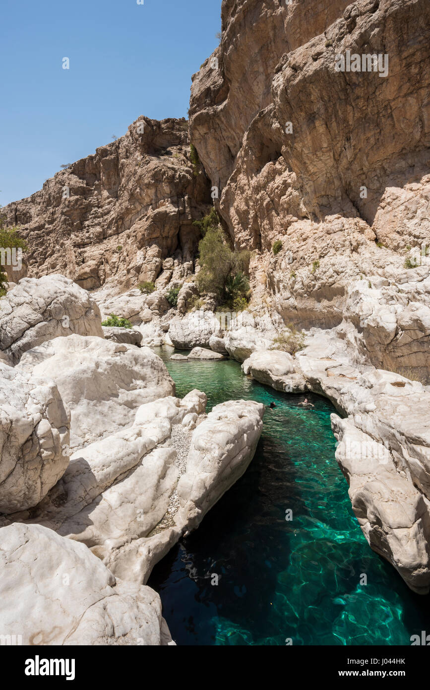 People enjoy swimming in the clear turquoise waters of Wadi Bani Khalid ...