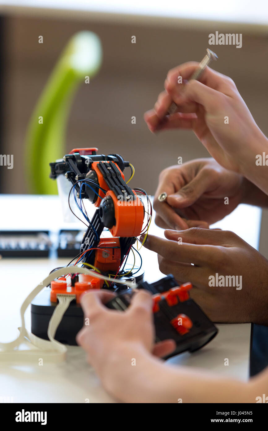 Close up shot of students hands working on a robotic arm Stock Photo ...
