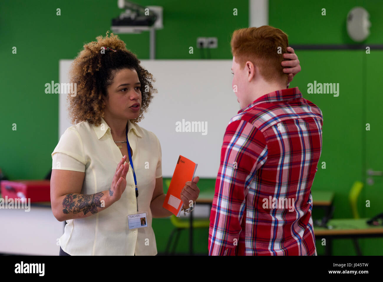 Teenage student being told off by his English teacher at school Stock ...
