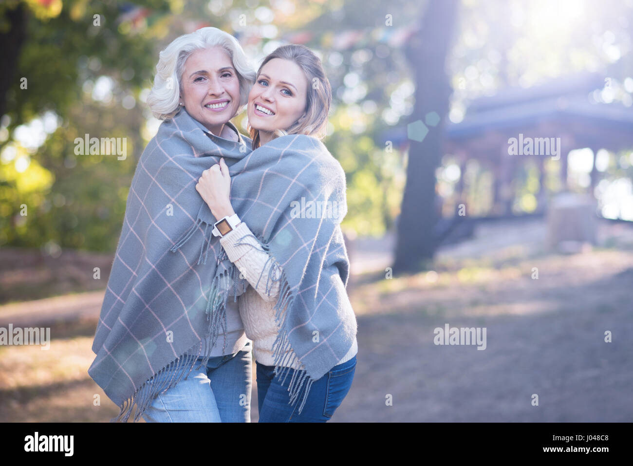 Charming woman hugging retired mother in the park Stock Photo - Alamy