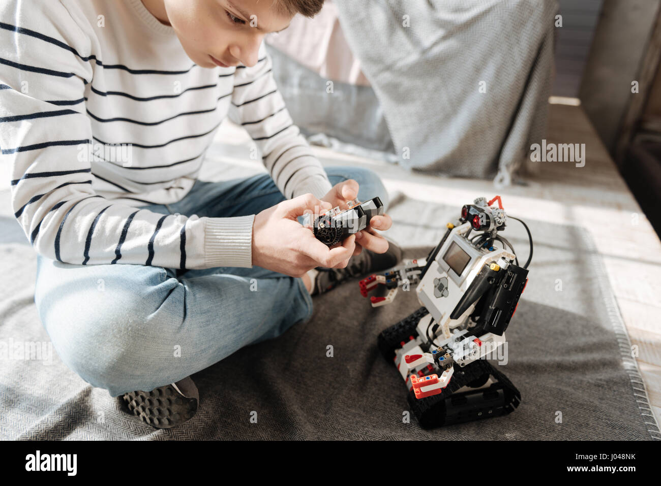 Close up photo of serious teenager while playing with robot Stock Photo ...