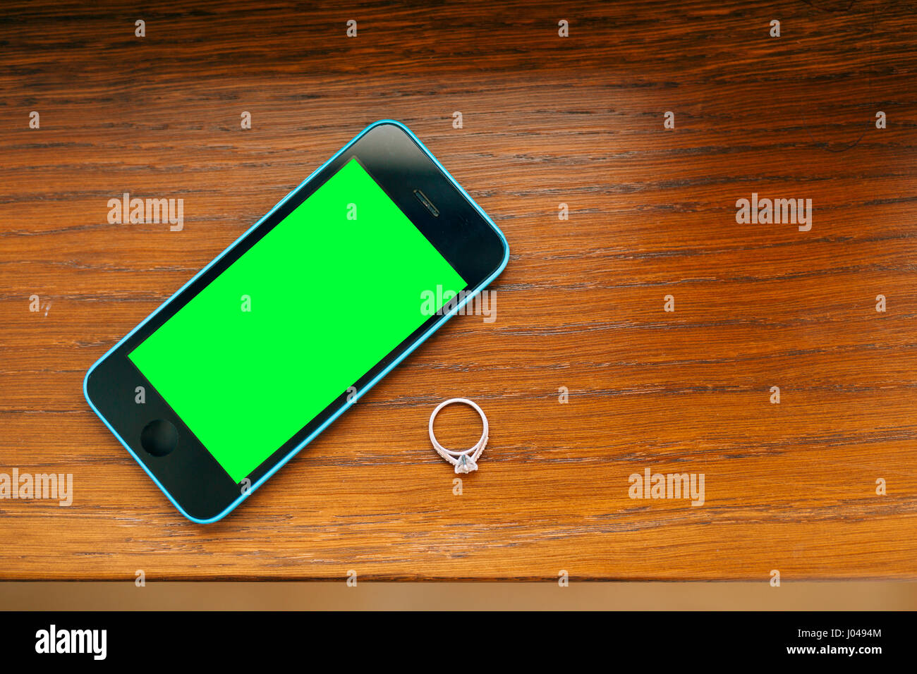 Wedding rings on a wooden texture, a blue and black smartphone w Stock ...