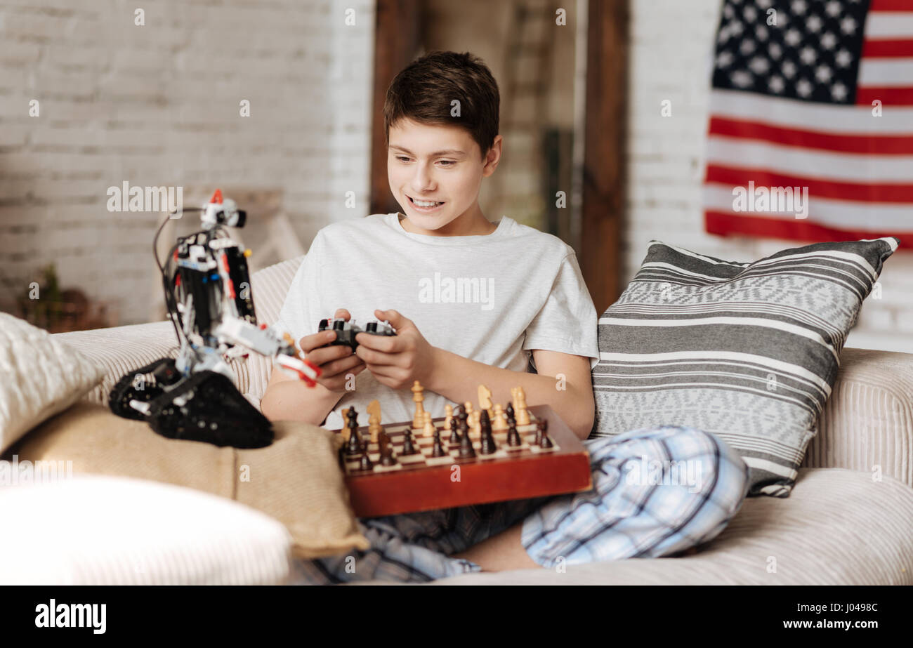 Make a move. Positive delighted man-child using console while ...