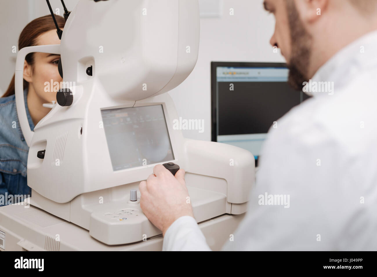 Professional male doctor using eye testing equipment Stock Photo - Alamy