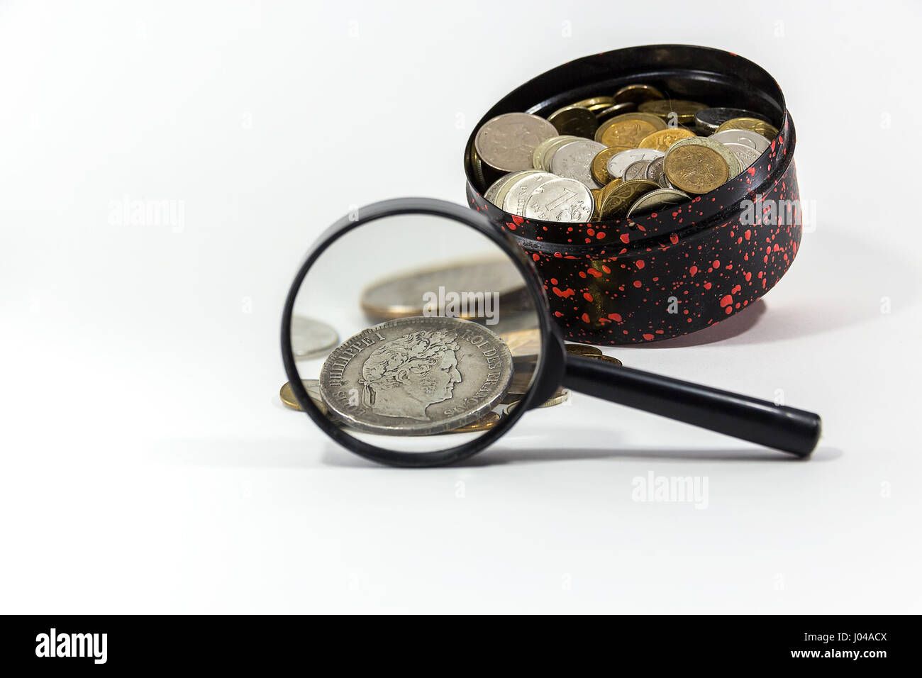 Silver coin under a magnifier on a background of a box with coins Stock ...