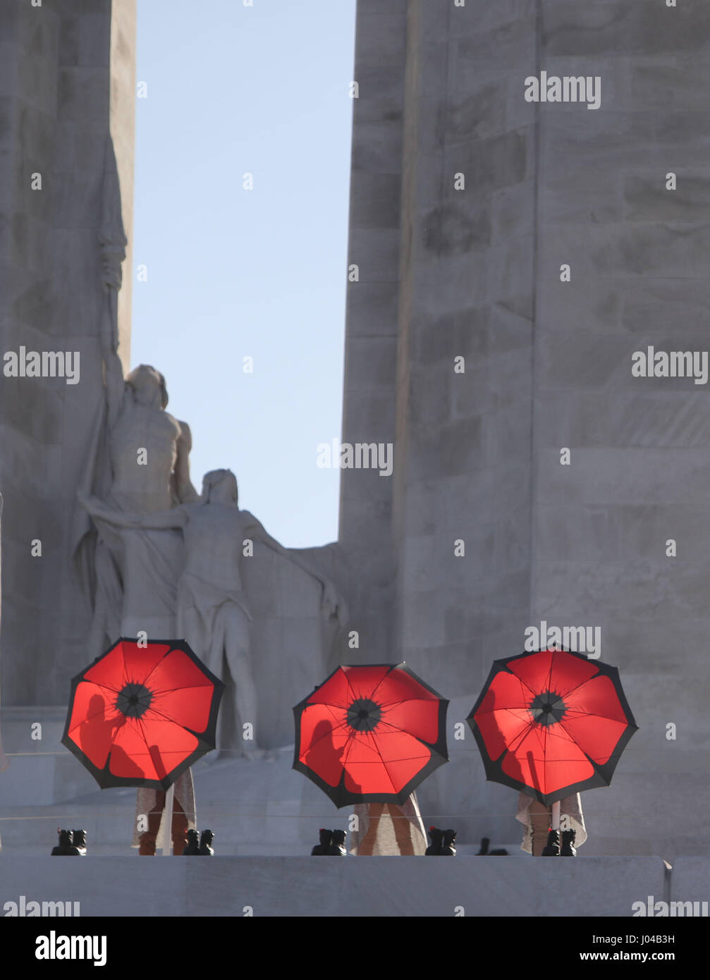 People holding poppy umbrellas at Vimy Memorial Park in France, during ...
