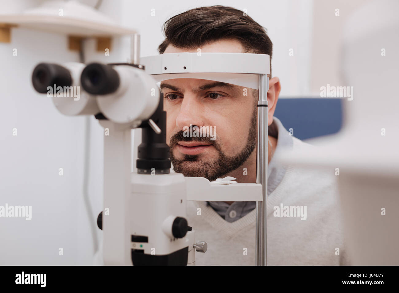 Serious handsome patient having his vision tested Stock Photo - Alamy