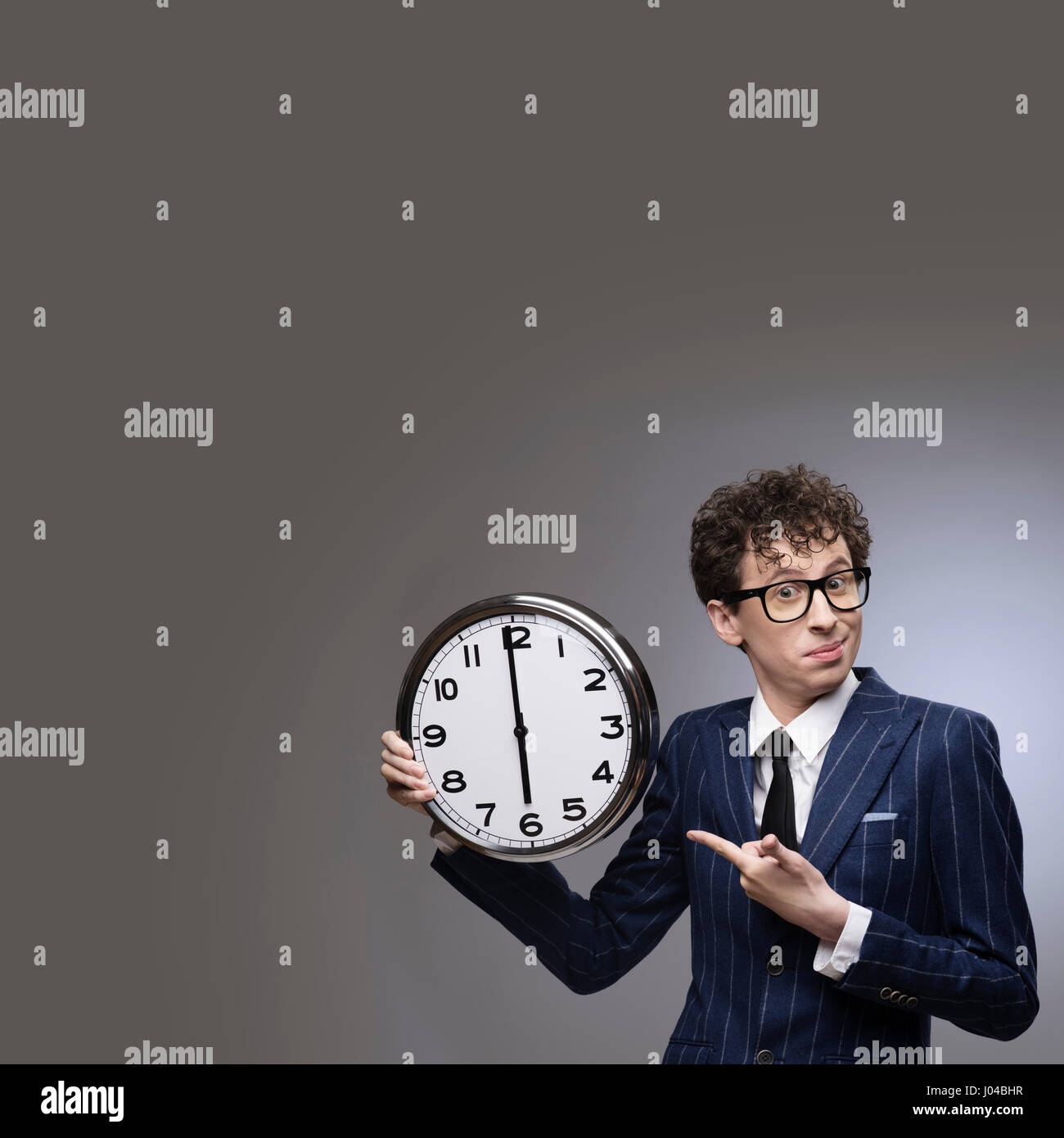 Funny businessman pointing to big wall clock showing time of deadline ...